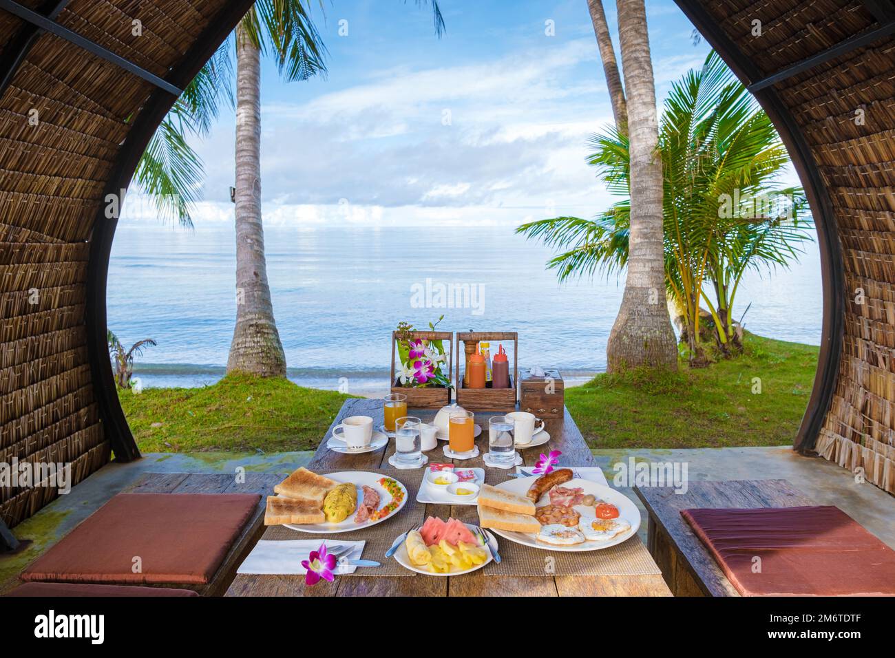 Breakfast table on the beach with palm trees in Thailand Stock Photo ...