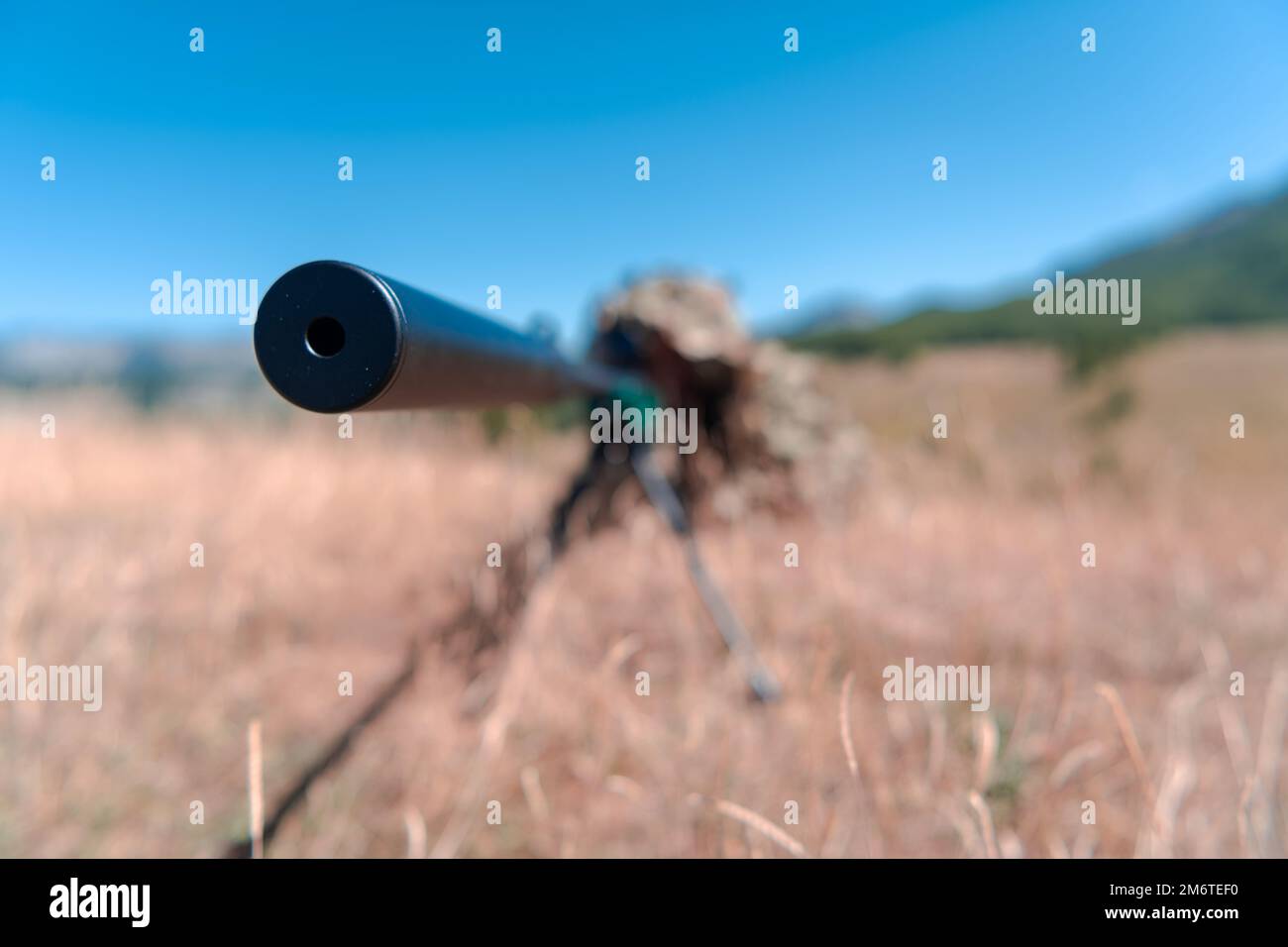 Army soldier holding sniper rifle with scope and aiming in forest. war ...