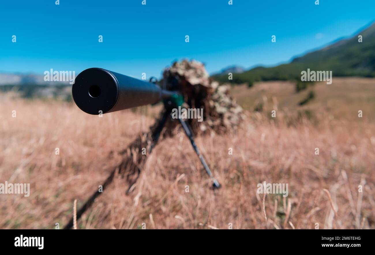 Army soldier holding sniper rifle with scope and aiming in forest. war ...