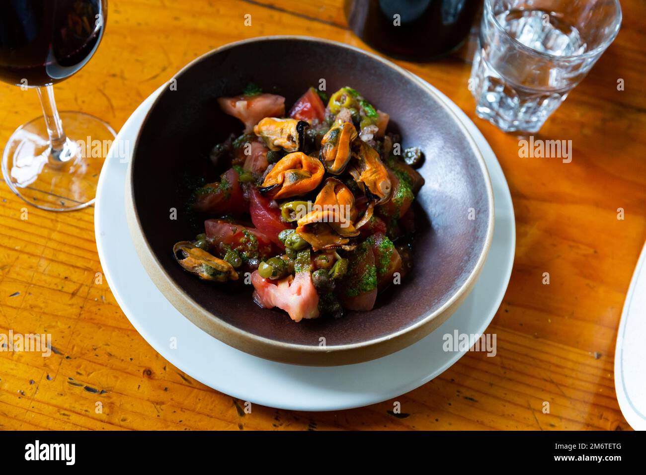 Tomatoes with arugula pesto and mussels served on plate Stock Photo - Alamy