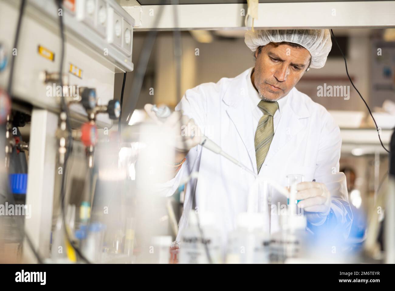 Male lab technician working with reagents in test tubes during chemical ...