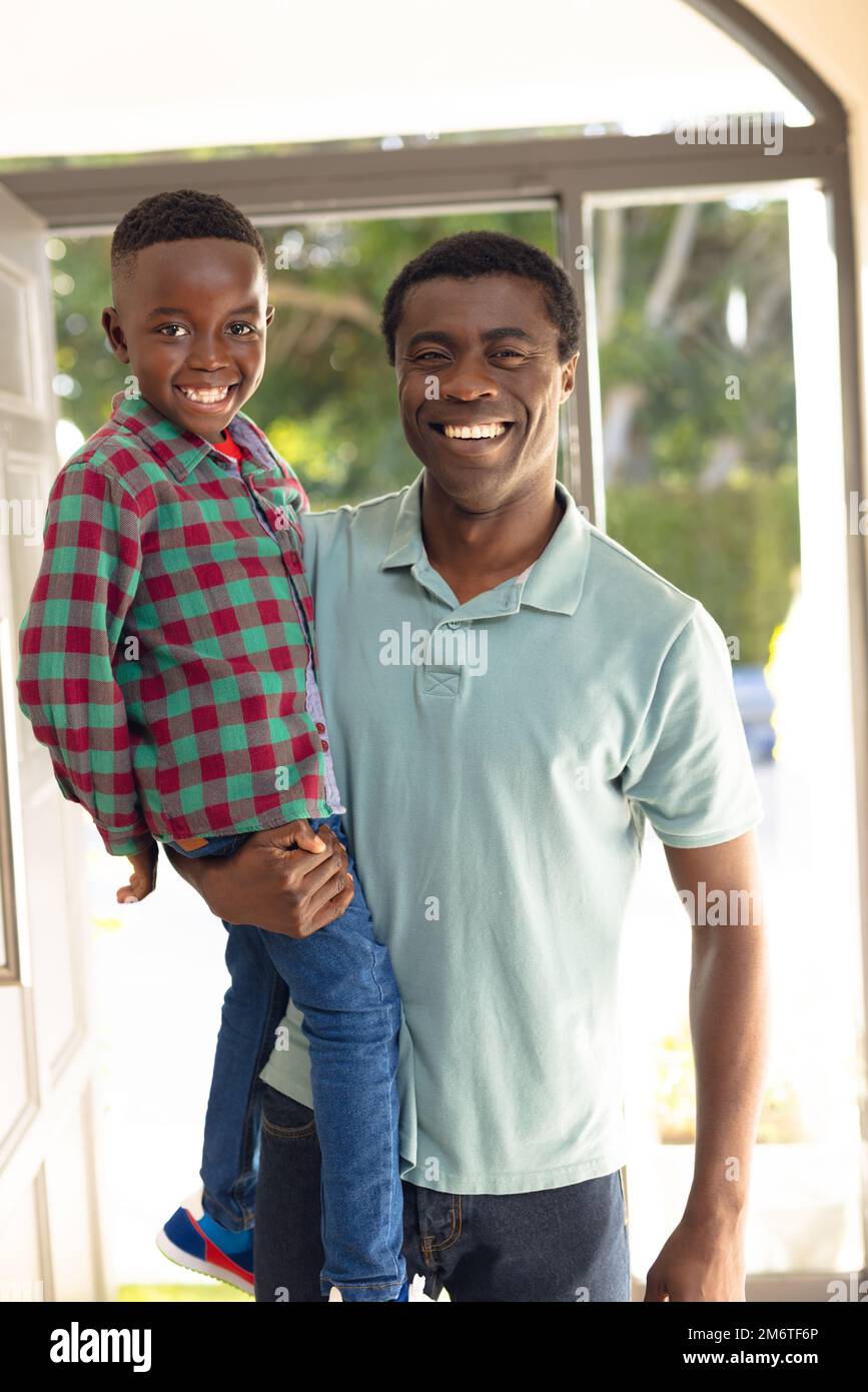 Vertical picture of happy african american son and father welcoming ...