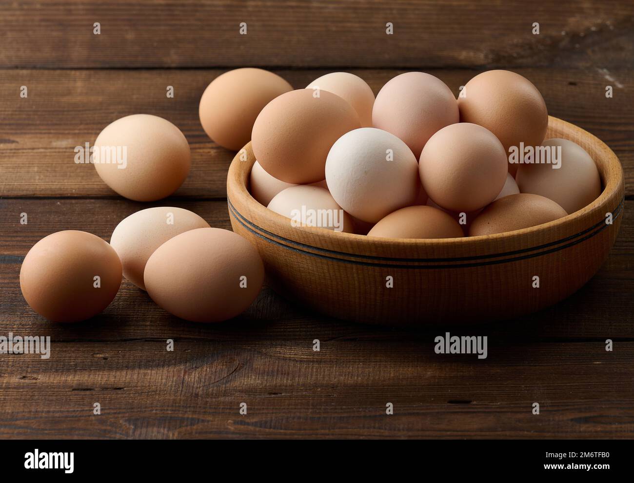 Fresh brown chicken eggs in a round wooden plate on the table Stock ...