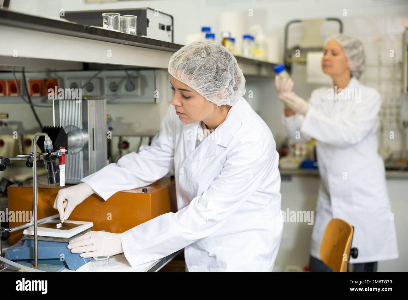 Female laboratory assistant weighs tablets on precision scales in ...