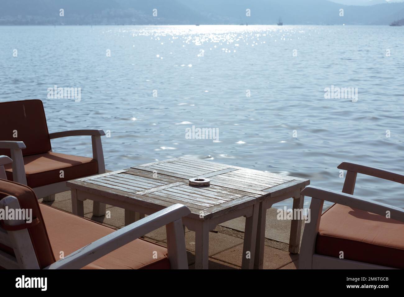 A table in an open-air restaurant with a sea view. Wooden dining table ...