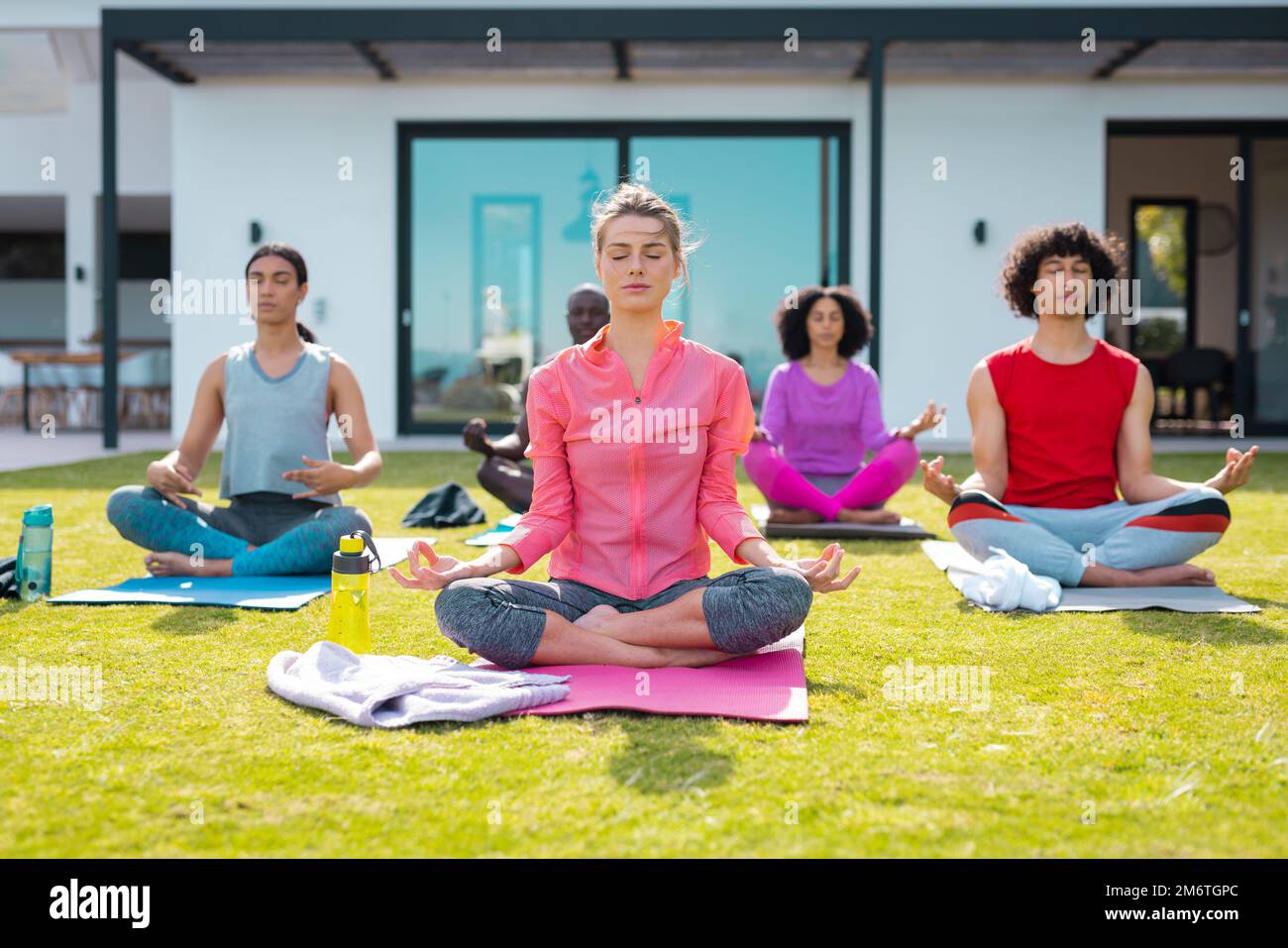 Diverse friends practicing yoga and meditating in garden Stock Photo ...