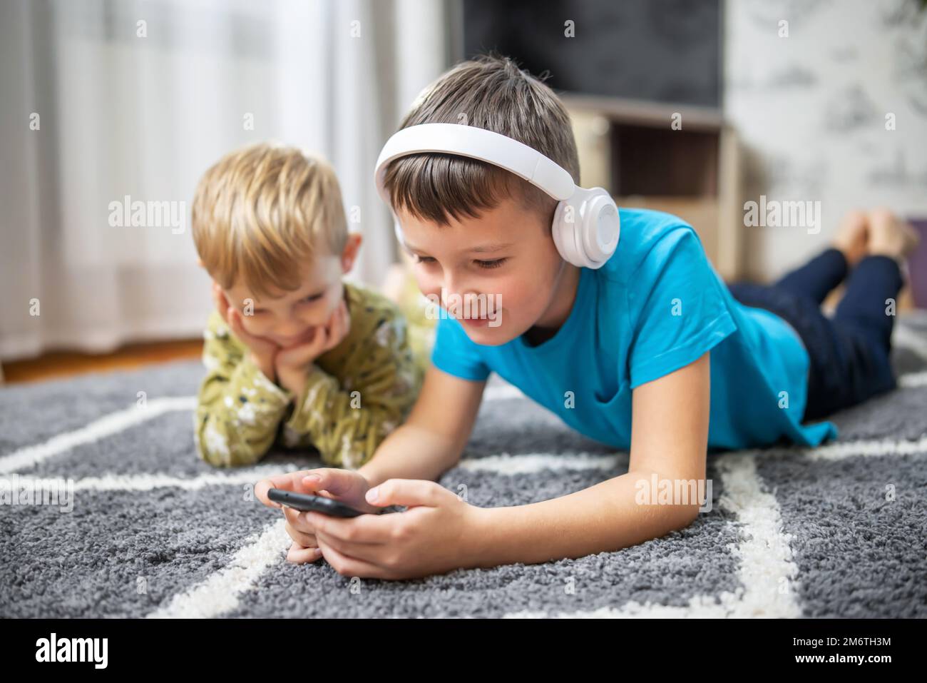 Two children watching smart phone, happy kids using smartphones ...