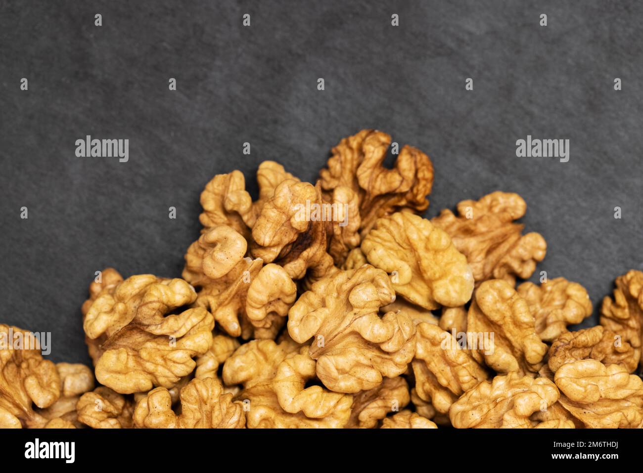 Walnuts. Walnut kernels on dark black stone background. Top view, flat ...
