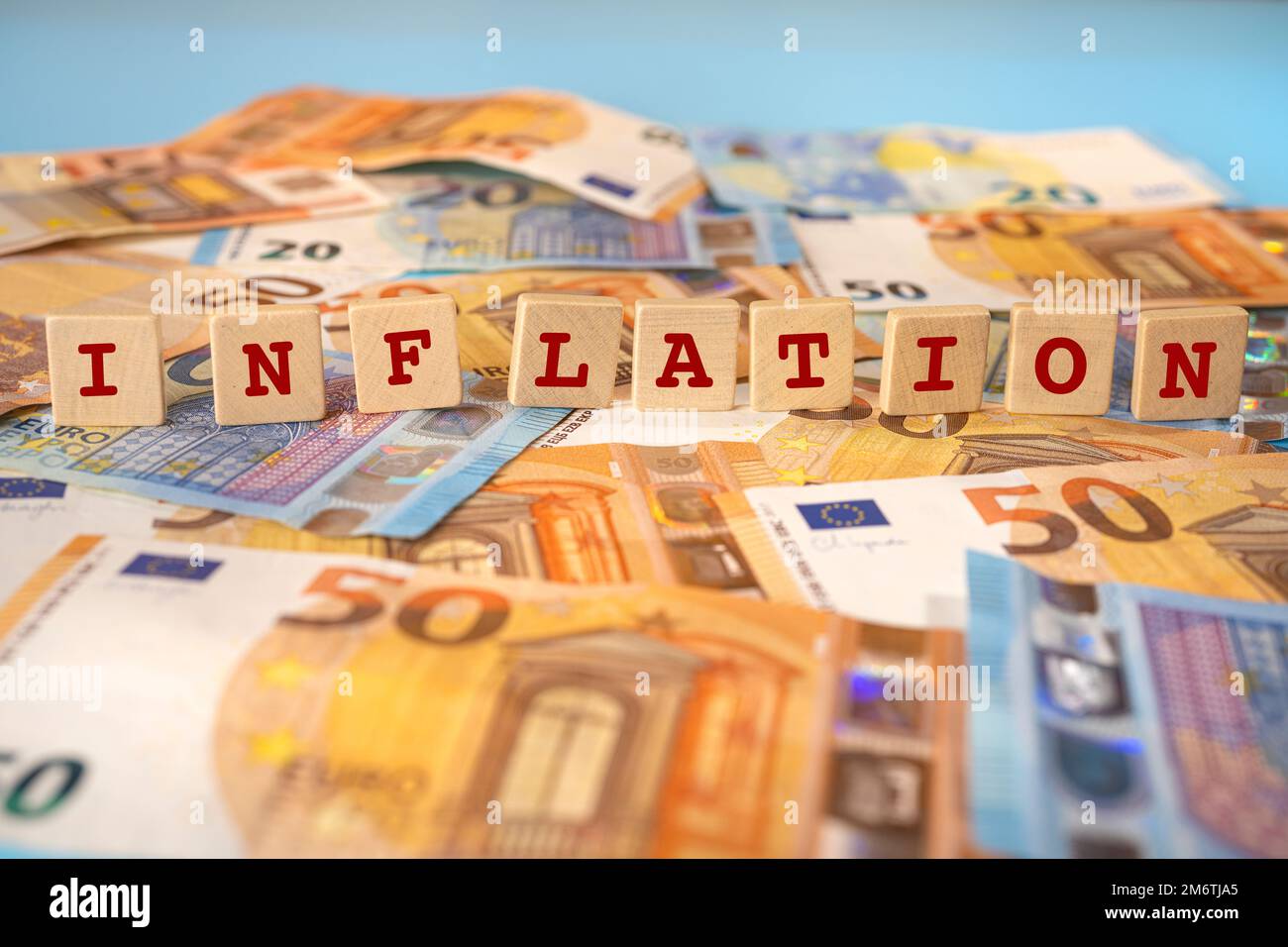 the word Inflation written on wooden dowels over a background of euro ...