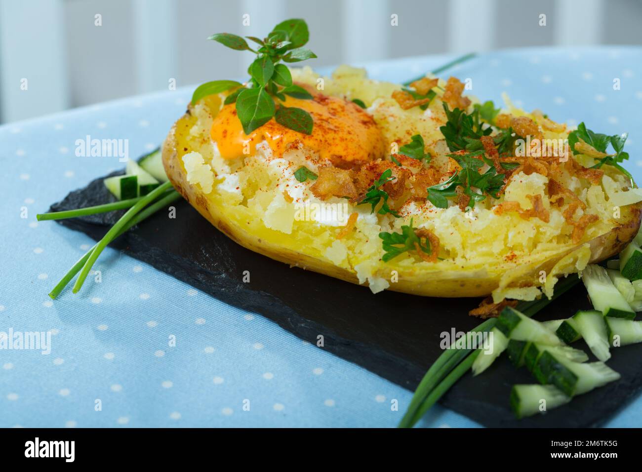 Baked potato with herbs, egg and cucumbers Stock Photo - Alamy