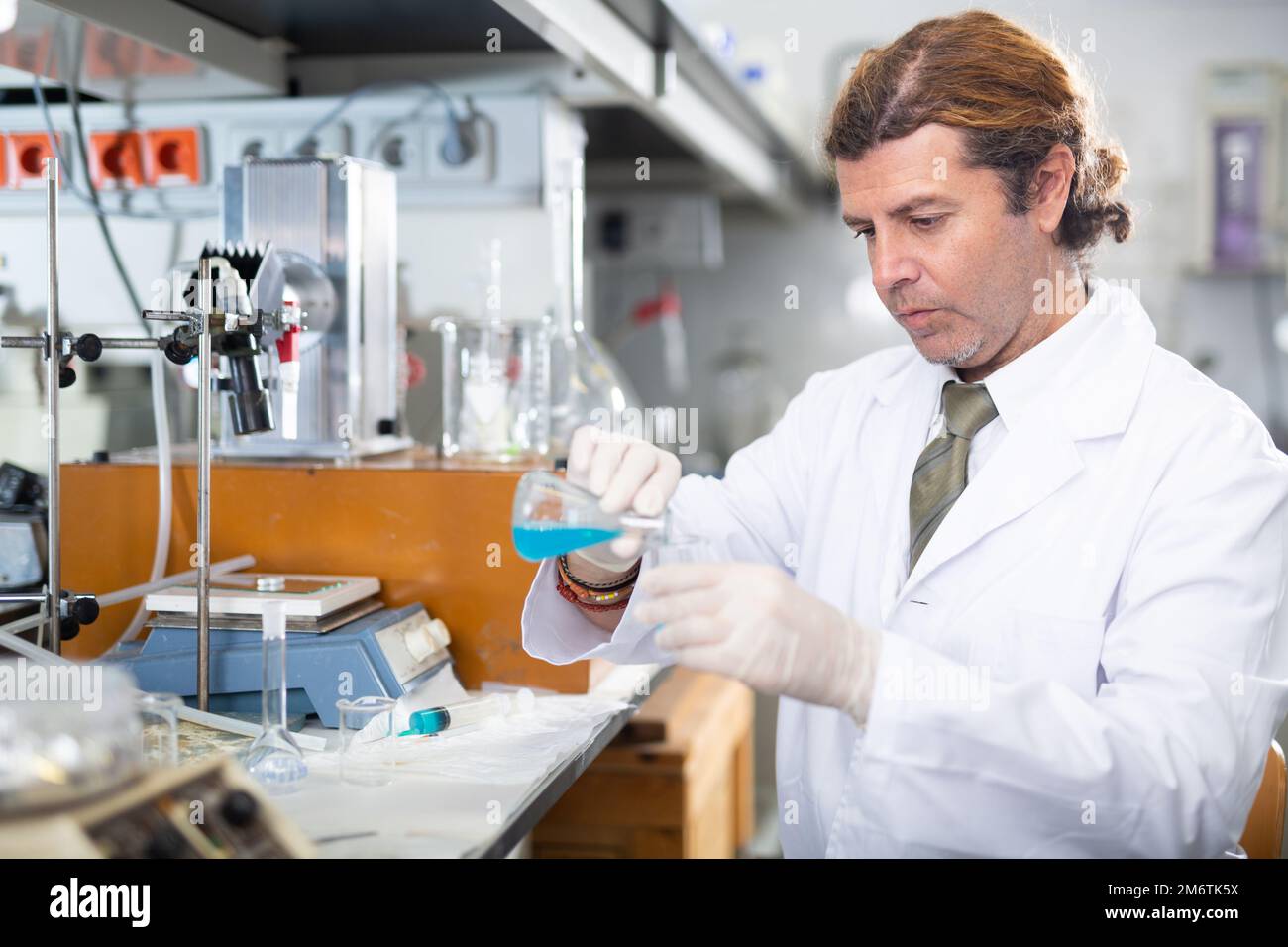 Professional Latin male biochemist investigating behavior of blue ...