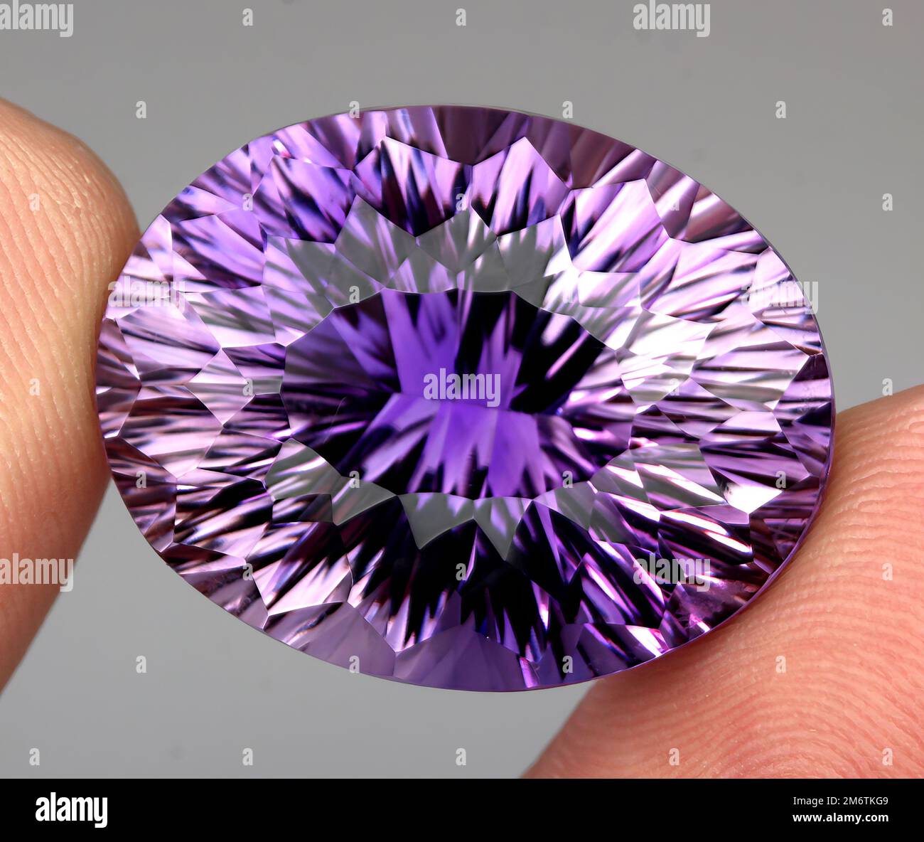 Natural stone purple amethyst on gray background Stock Photo - Alamy