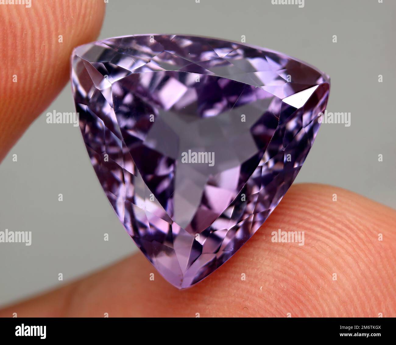 Natural stone purple amethyst on gray background Stock Photo - Alamy