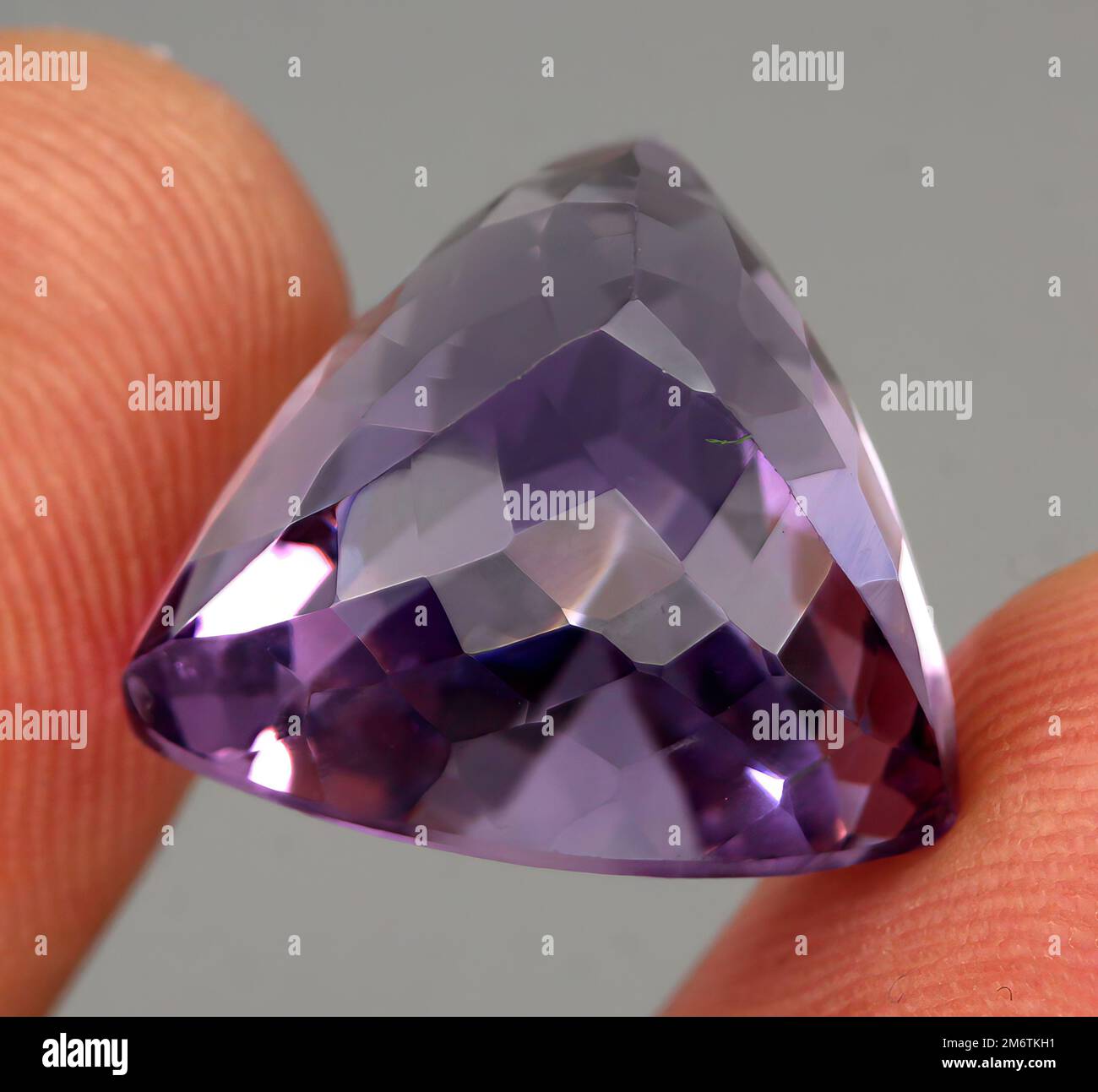 Natural stone purple amethyst on gray background Stock Photo - Alamy