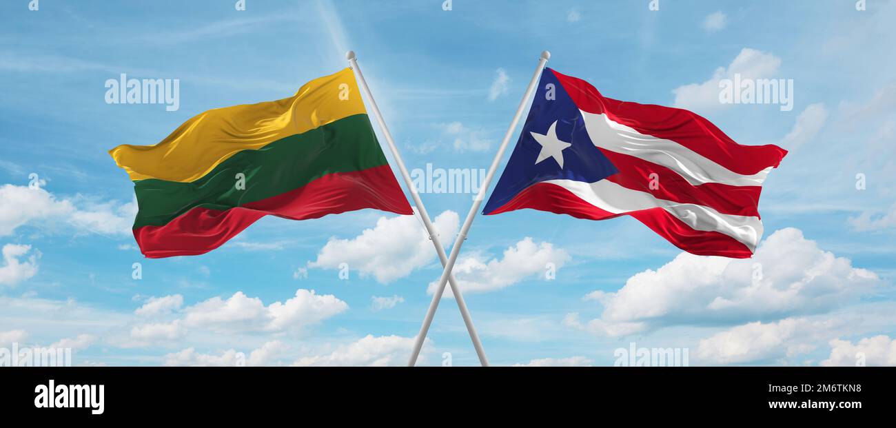 two crossed flags Puerto Rico and Lithuania waving in wind at cloudy sky. Concept of ...
