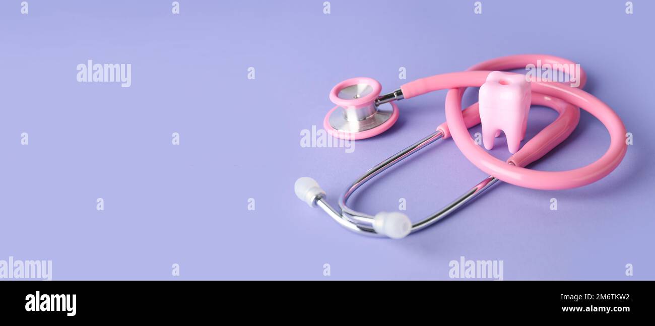 Plastic tooth and stethoscope on lilac background with space for text ...