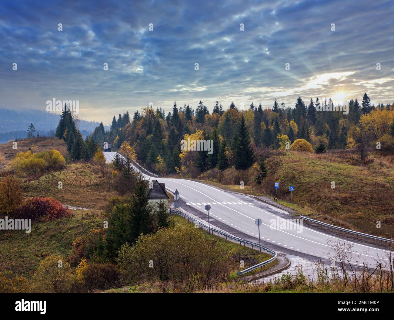 Hazy and overcast Carpathian Mountains and highway on mountain pass ...