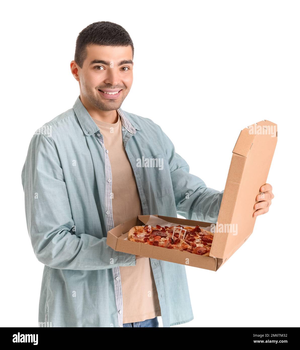 Handsome young man holding box with fresh pizza on white background ...