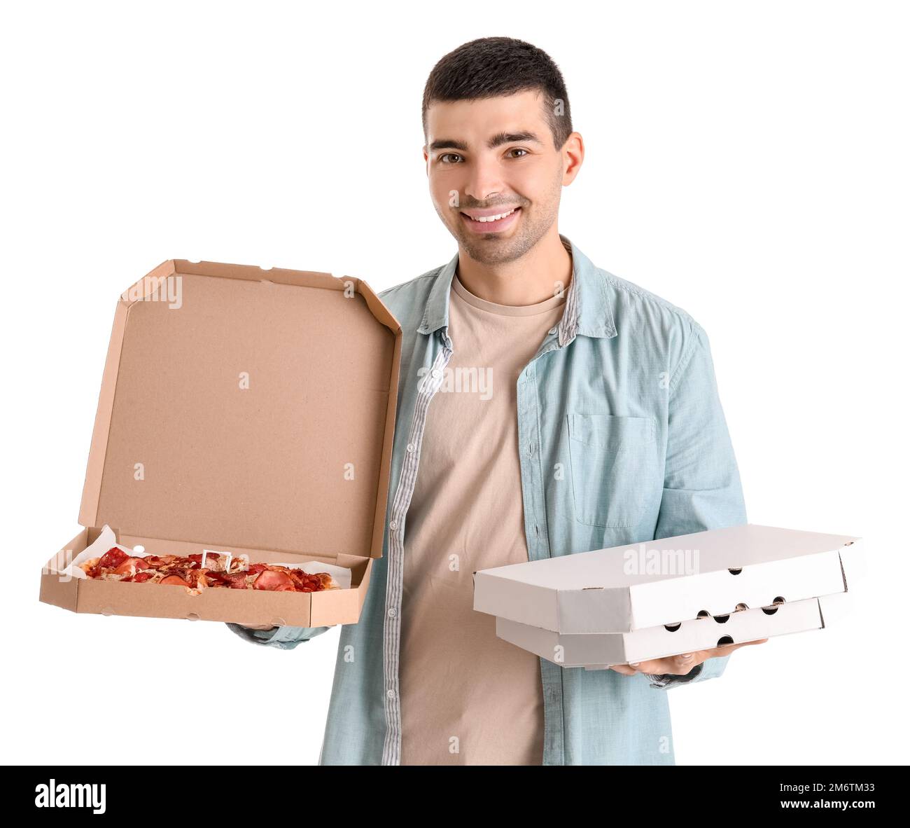 Handsome young man holding boxes with fresh pizza on white background ...