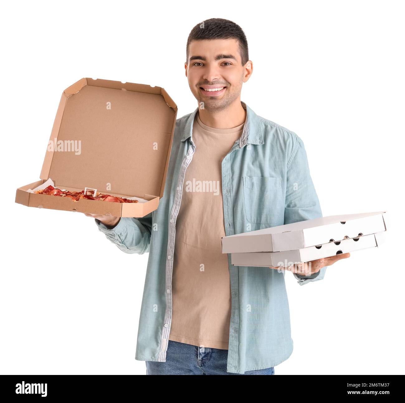 Handsome young man holding boxes with fresh pizza on white background ...