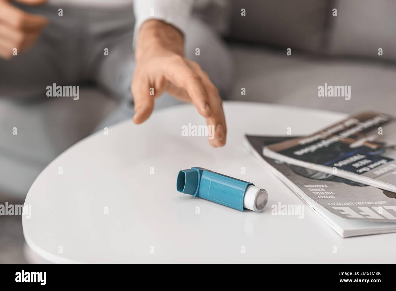 Man taking inhaler from table, closeup Stock Photo - Alamy