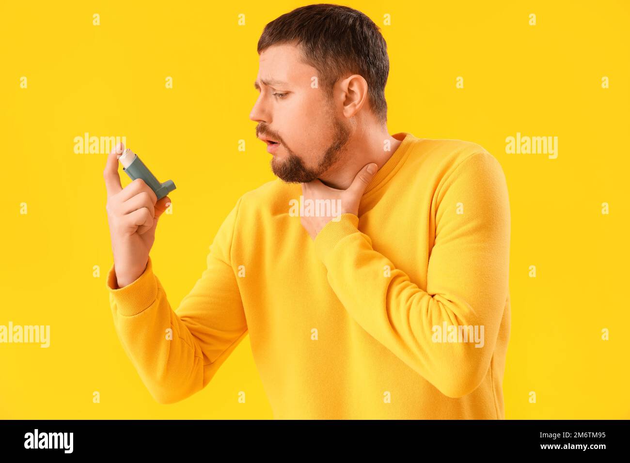 Sick man with inhaler on yellow background Stock Photo - Alamy