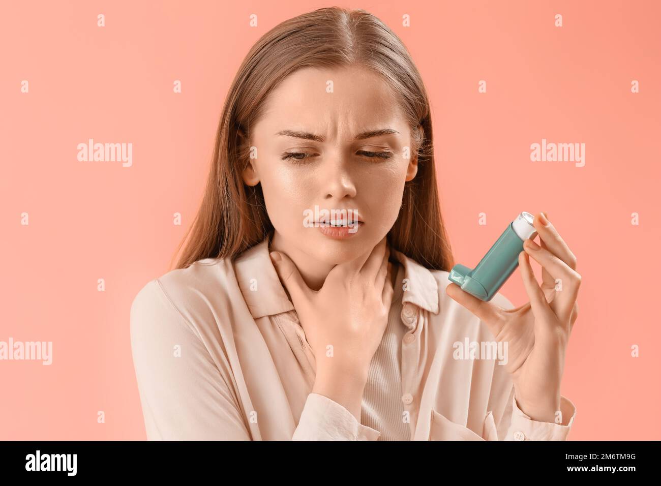 Sick young woman with inhaler on pink background Stock Photo - Alamy