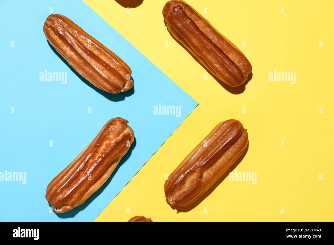 Composition with sweet eclairs on color background Stock Photo - Alamy