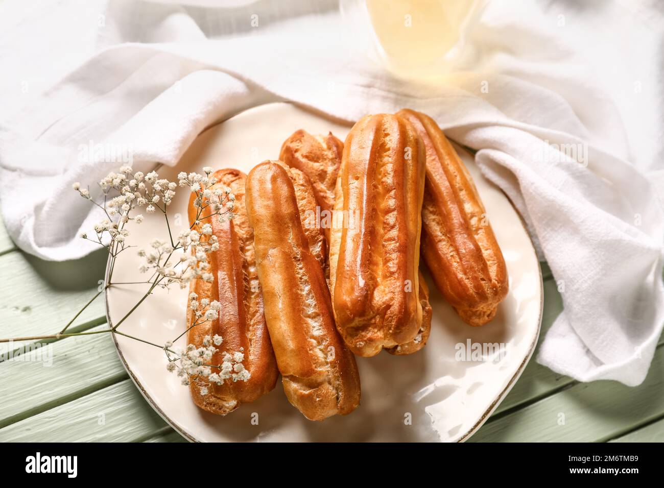 Plate with sweet eclairs on color wooden background, closeup Stock ...