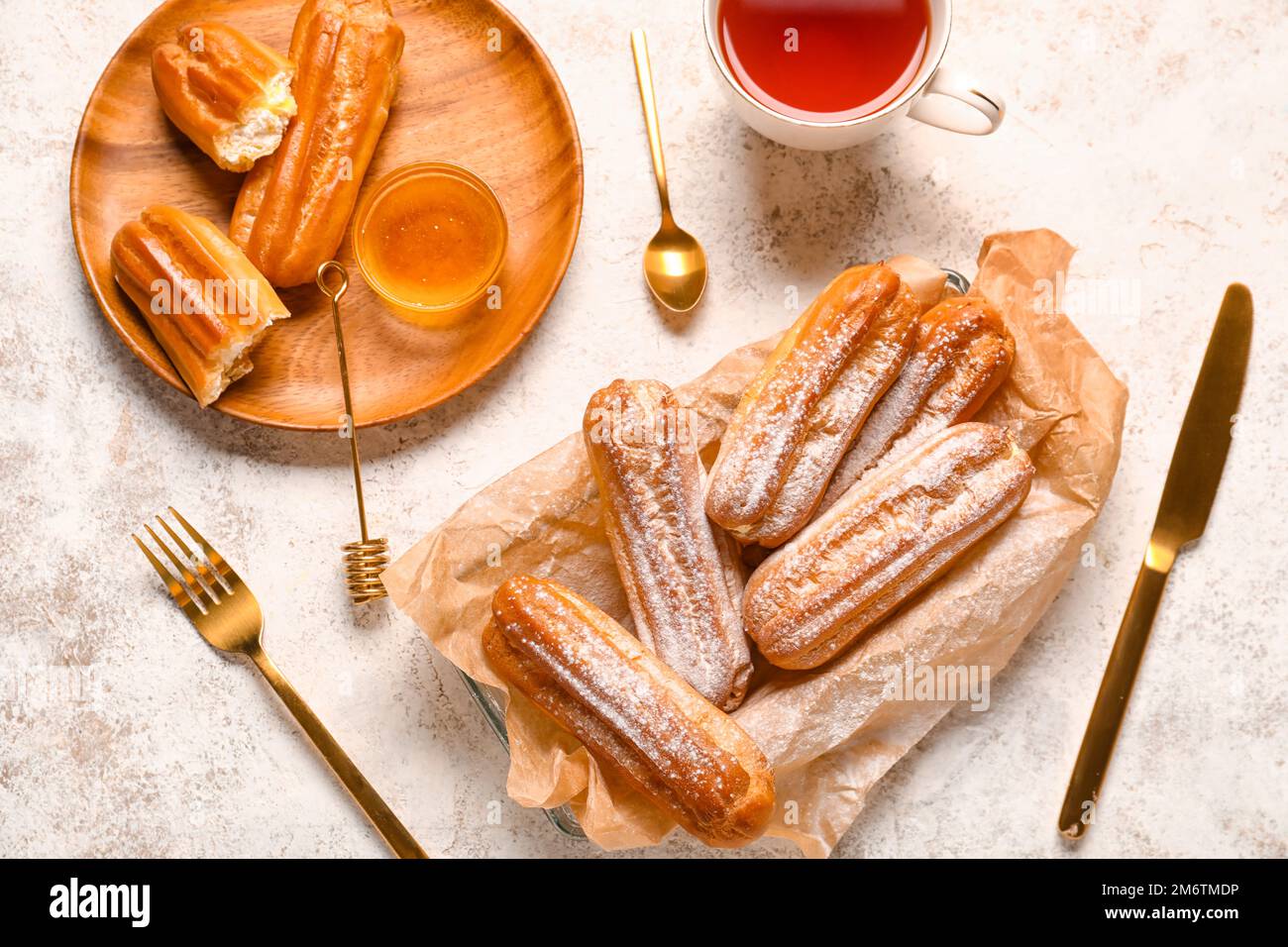 Composition with sweet eclairs and honey on light background Stock ...