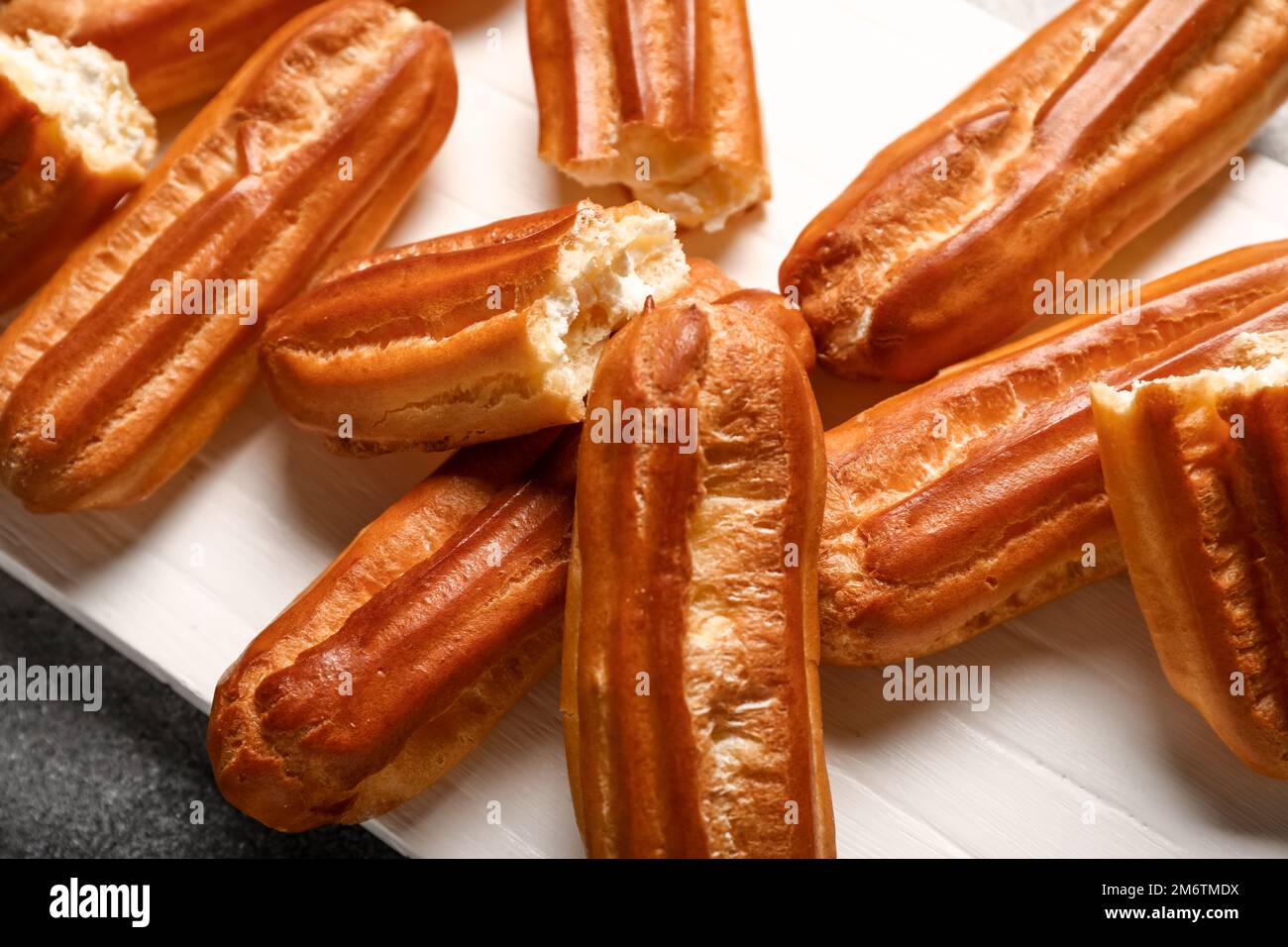 Light wooden board with sweet eclairs, closeup Stock Photo - Alamy