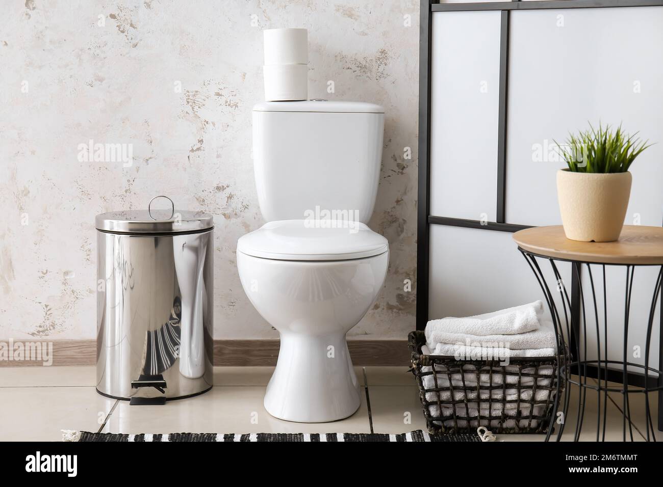 Interior of restroom with toilet bowl, table and folding screen Stock ...