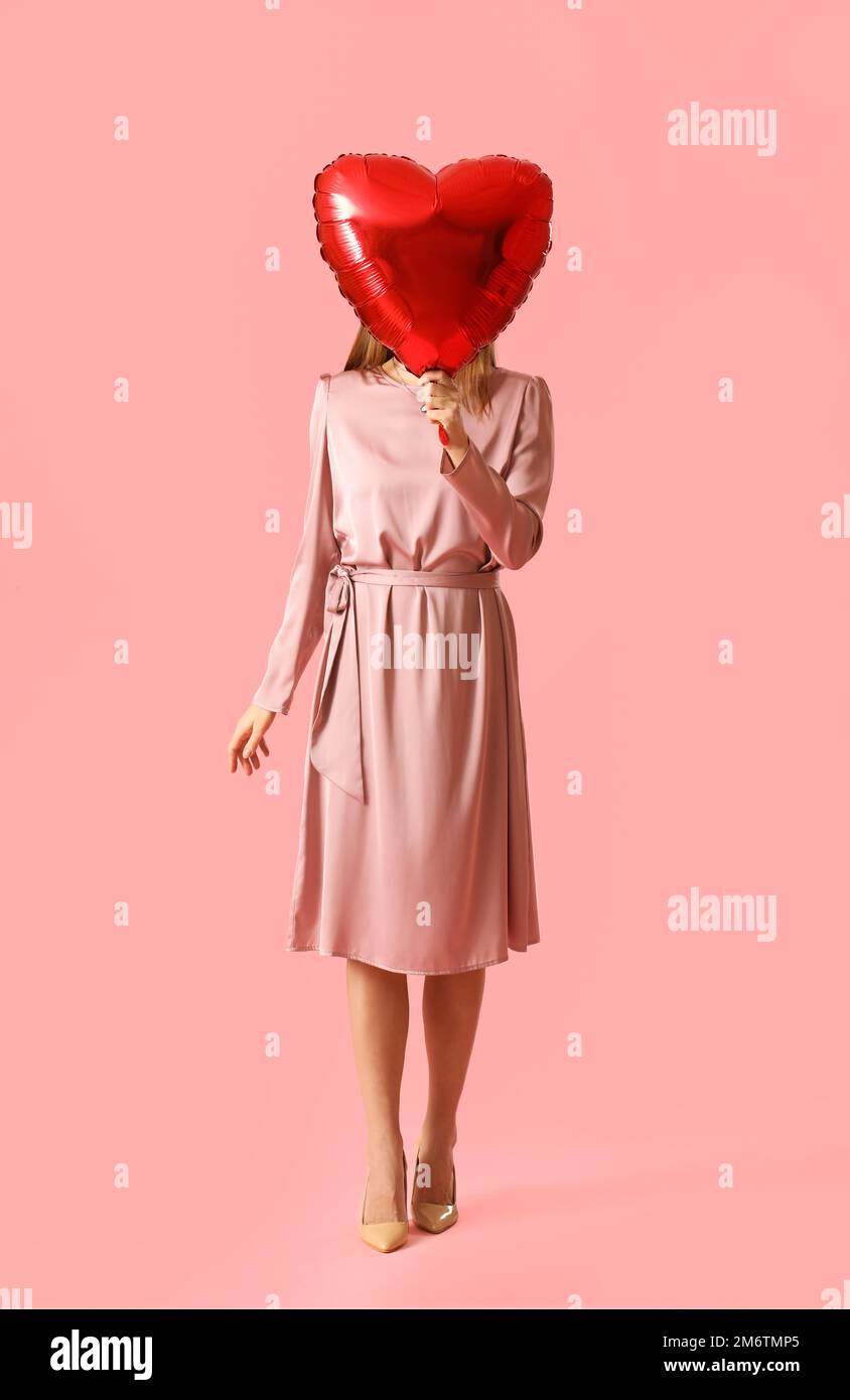 Young woman with balloon for Valentine's Day on pink background Stock ...