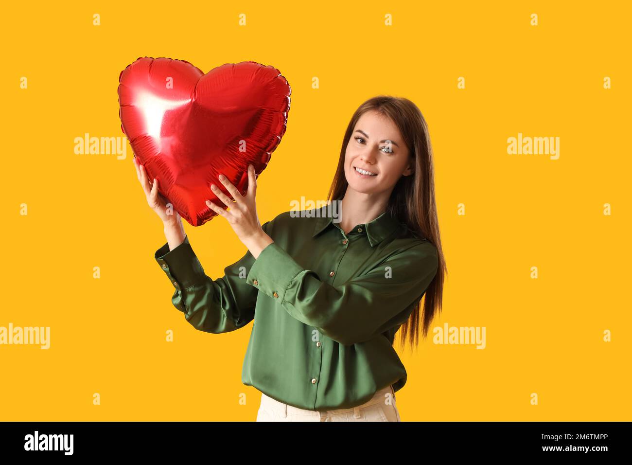 Young woman with balloon for Valentine's Day on yellow background Stock ...