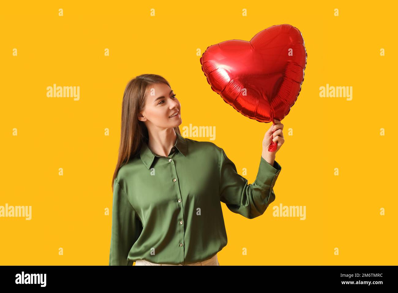 Young woman with balloon for Valentine's Day on yellow background Stock ...