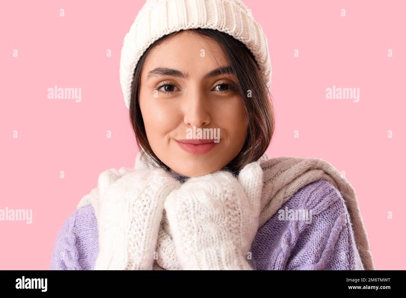 Frozen young woman in winter clothes on pink background, closeup Stock ...