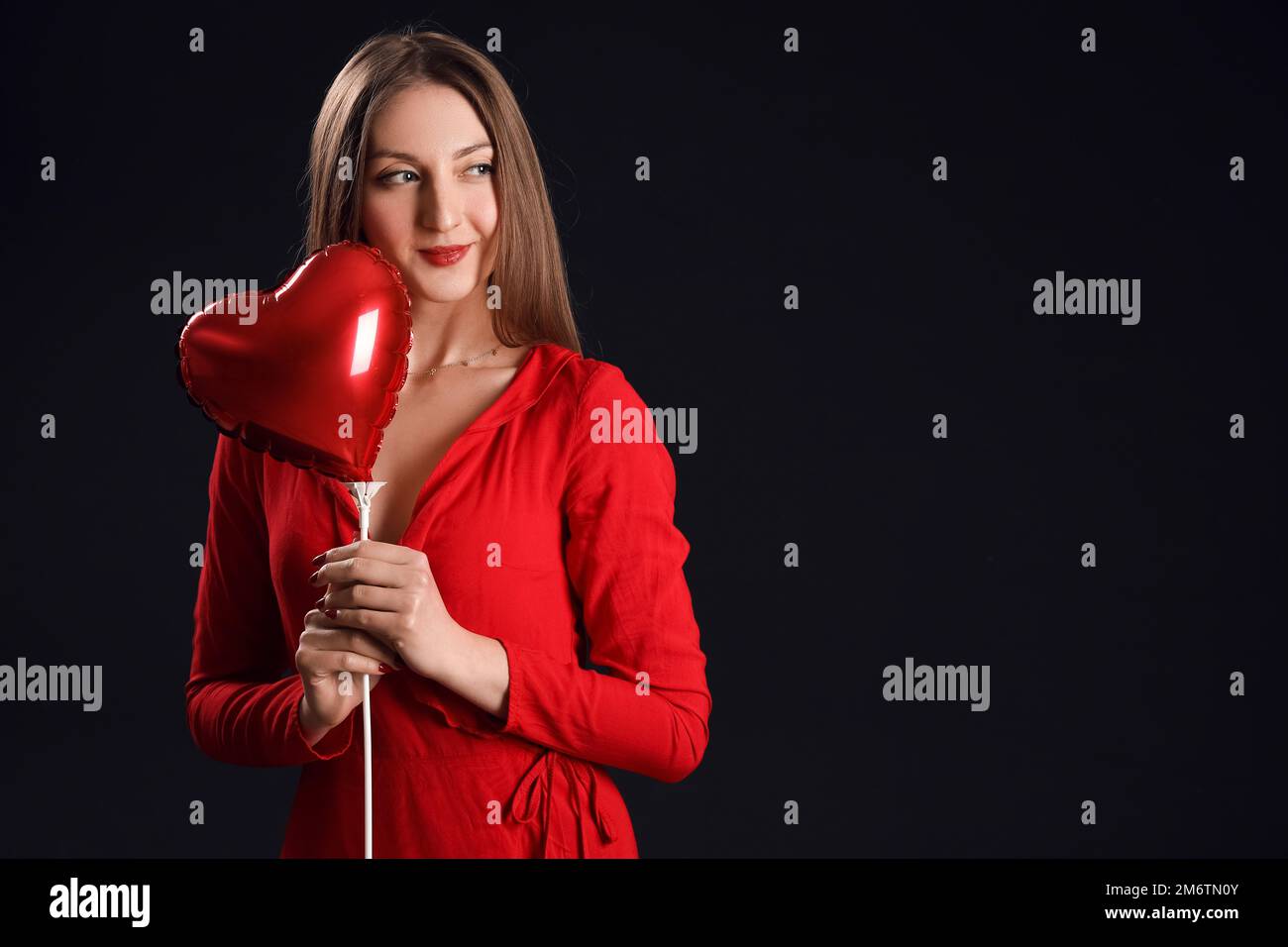 Young woman with balloon on black background. Valentine's Day ...