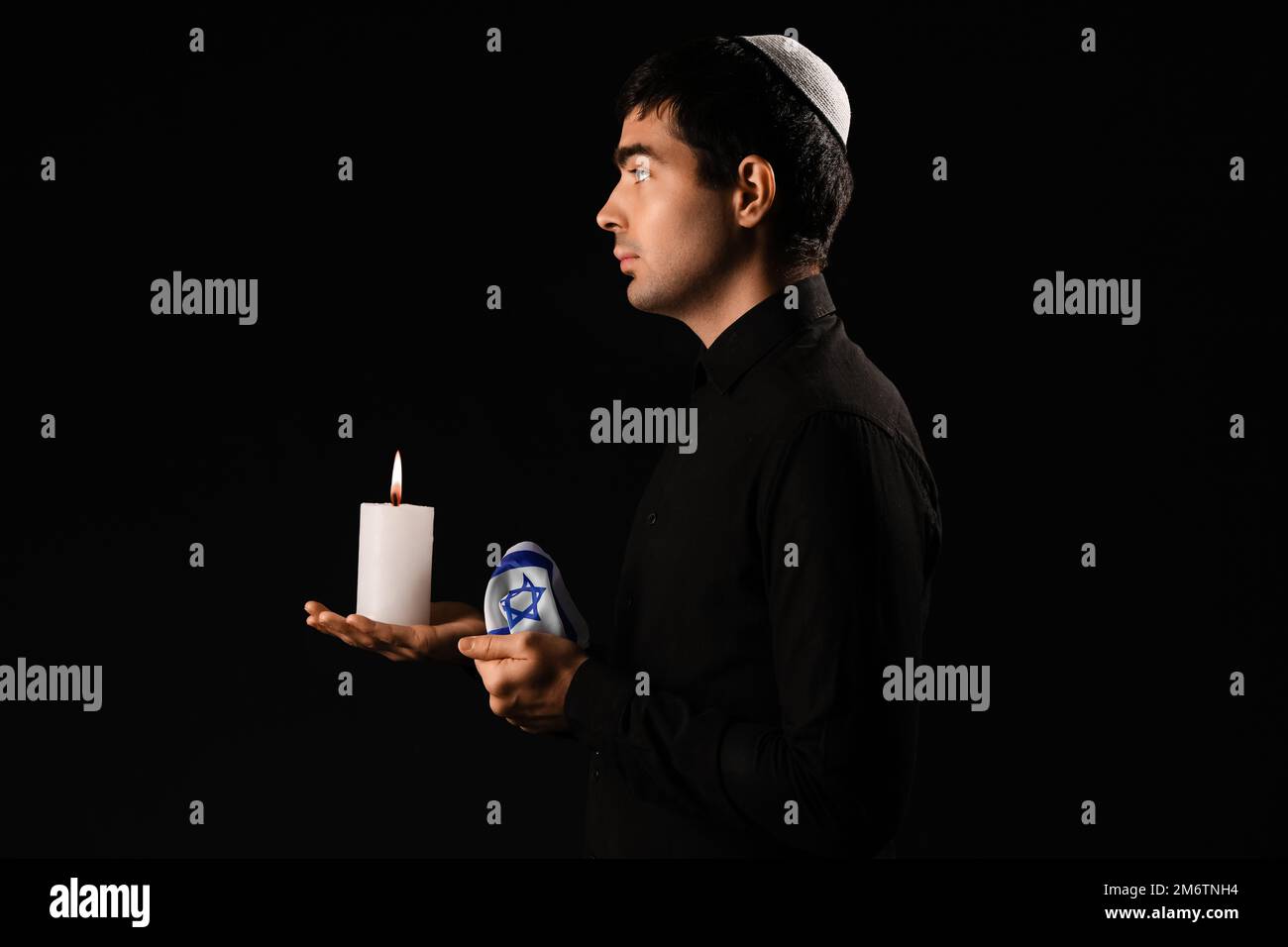 Jewish man with candle and flag of Israel on dark background ...