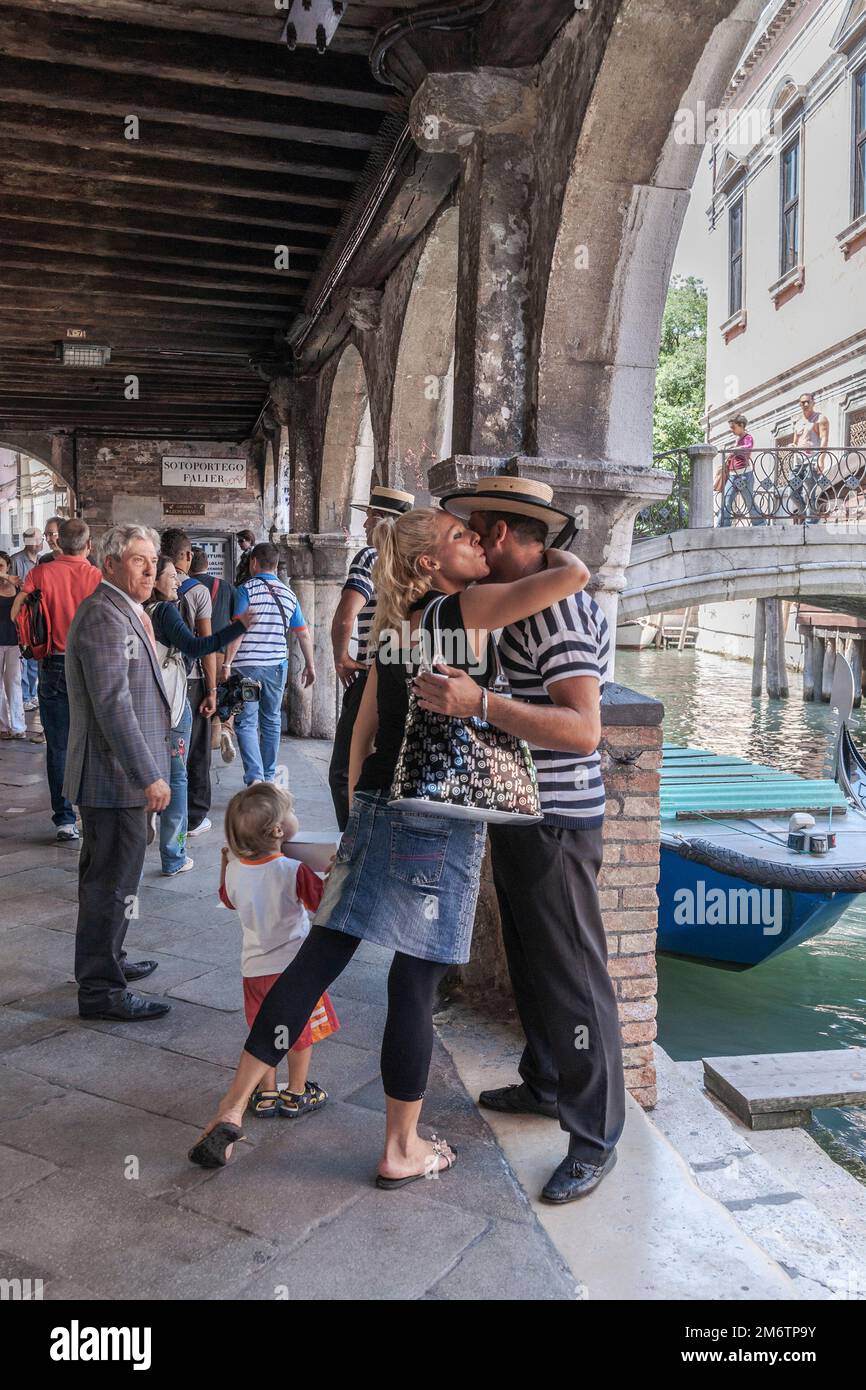 A woman embraces a gondolier at the side of a canal in Venice Stock ...