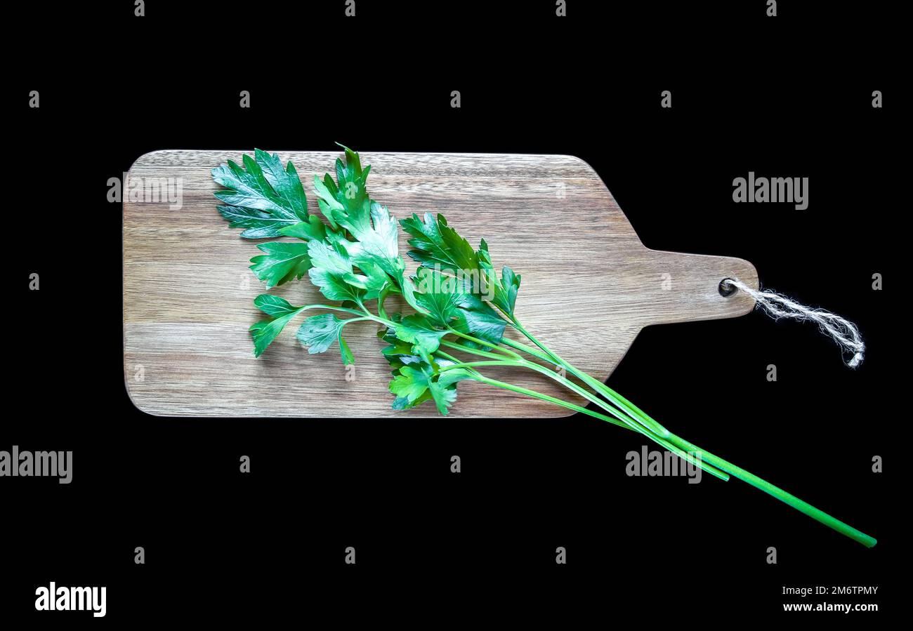 Bunch of parsley stem on a wooden cutting board Stock Photo - Alamy