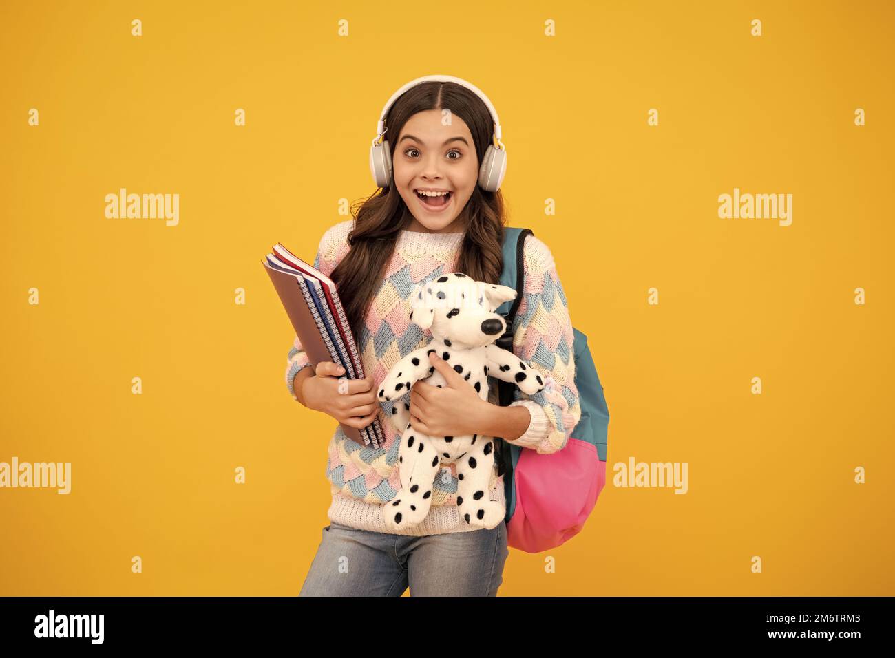 Excited face. Funny school girl with toy isolated on yellow background ...