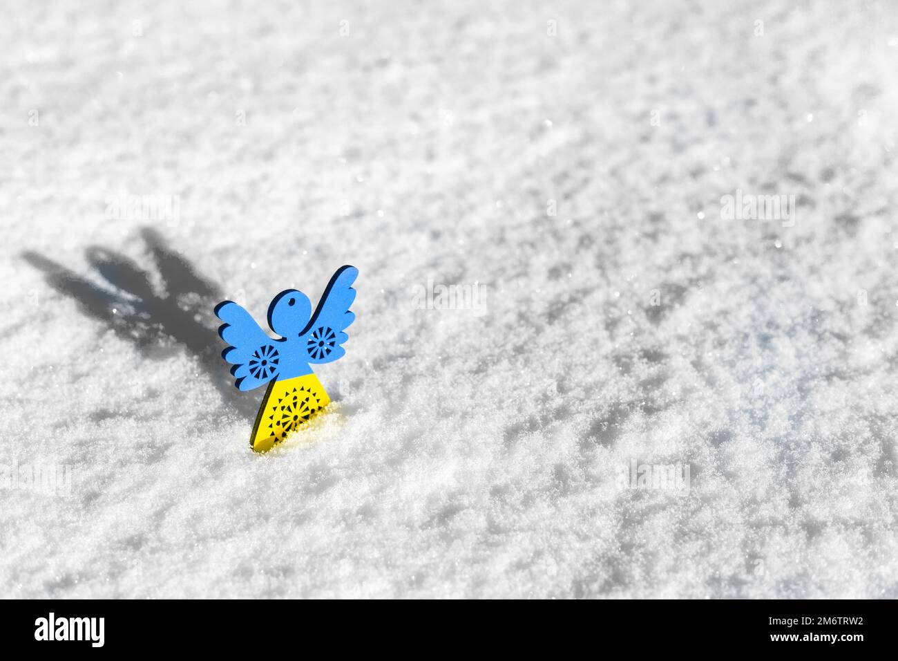 blue and yellow toy angel on white snow Stock Photo - Alamy