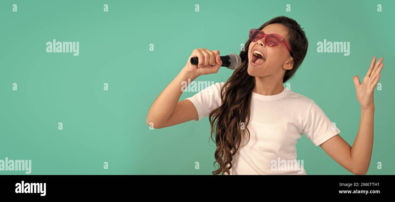 Happy kid singer sing karaoke song to microphone blue background, music ...