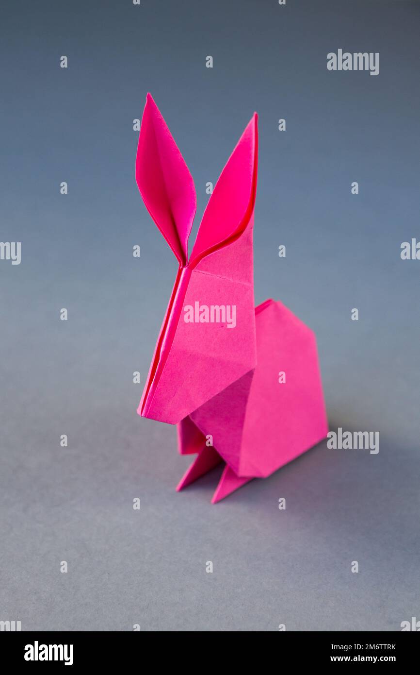 Pink paper rabbit origami isolated on a grey background Stock Photo - Alamy