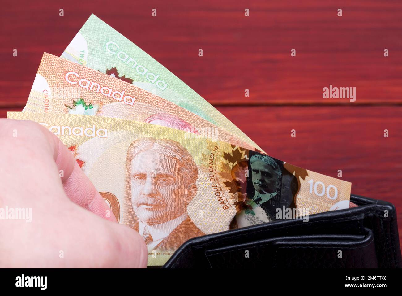 Canadian money in the black wallet Stock Photo - Alamy