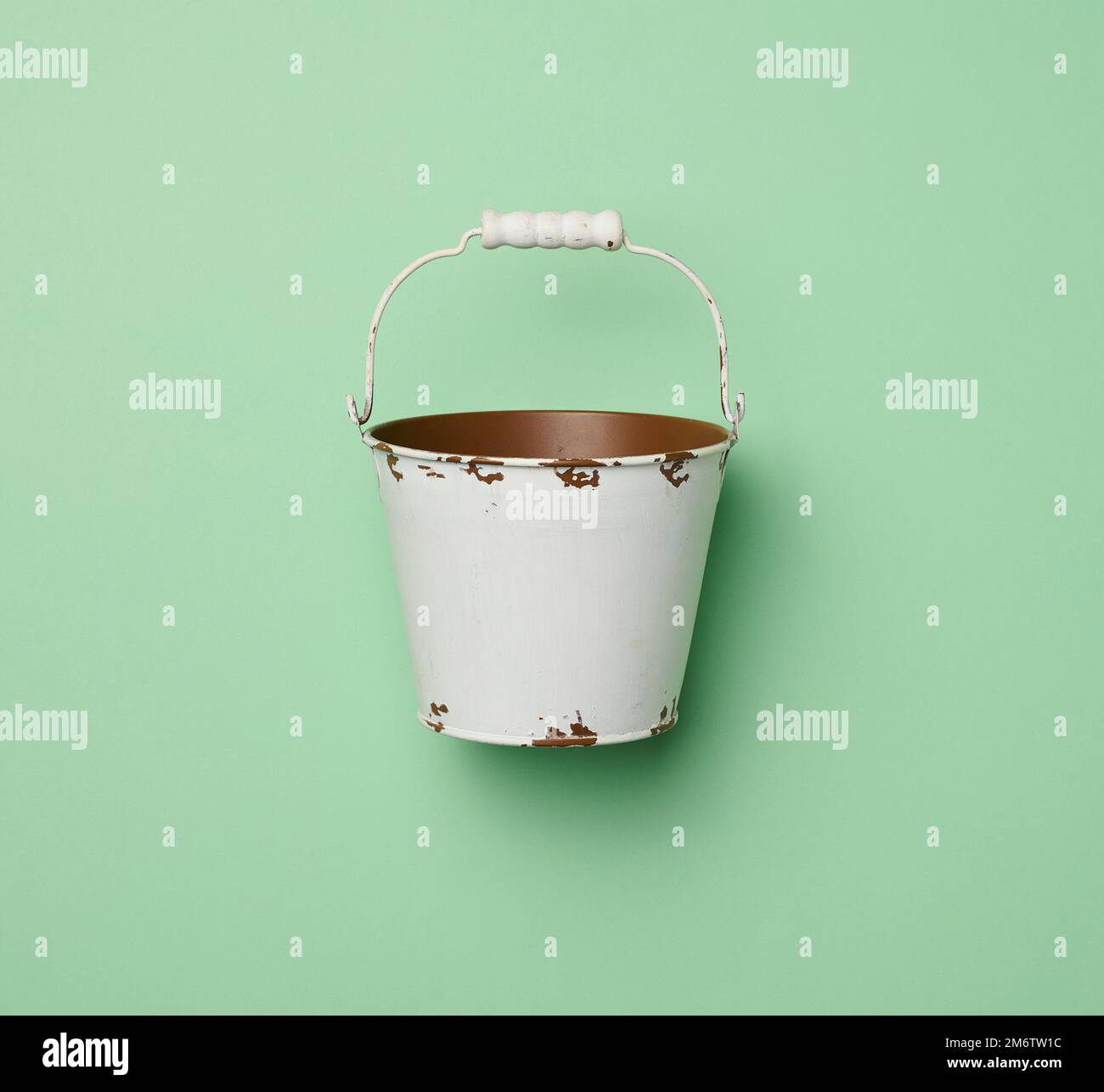 Miniature small white bucket on a green background Stock Photo - Alamy