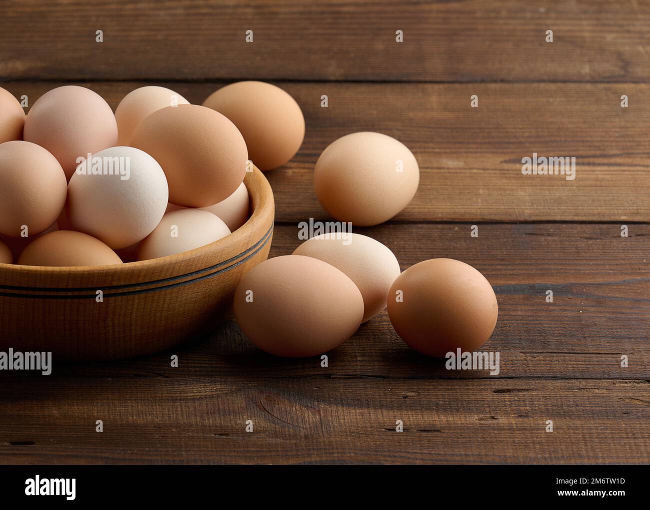 Fresh brown chicken eggs in a round wooden plate on the table Stock ...