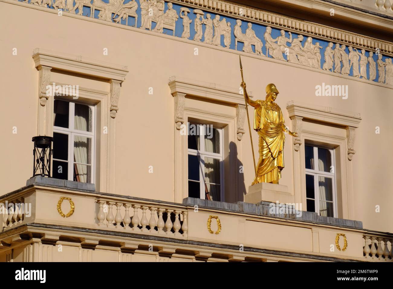 The Athenaeum club with frieze and gilded figure of Athena glowing gold ...