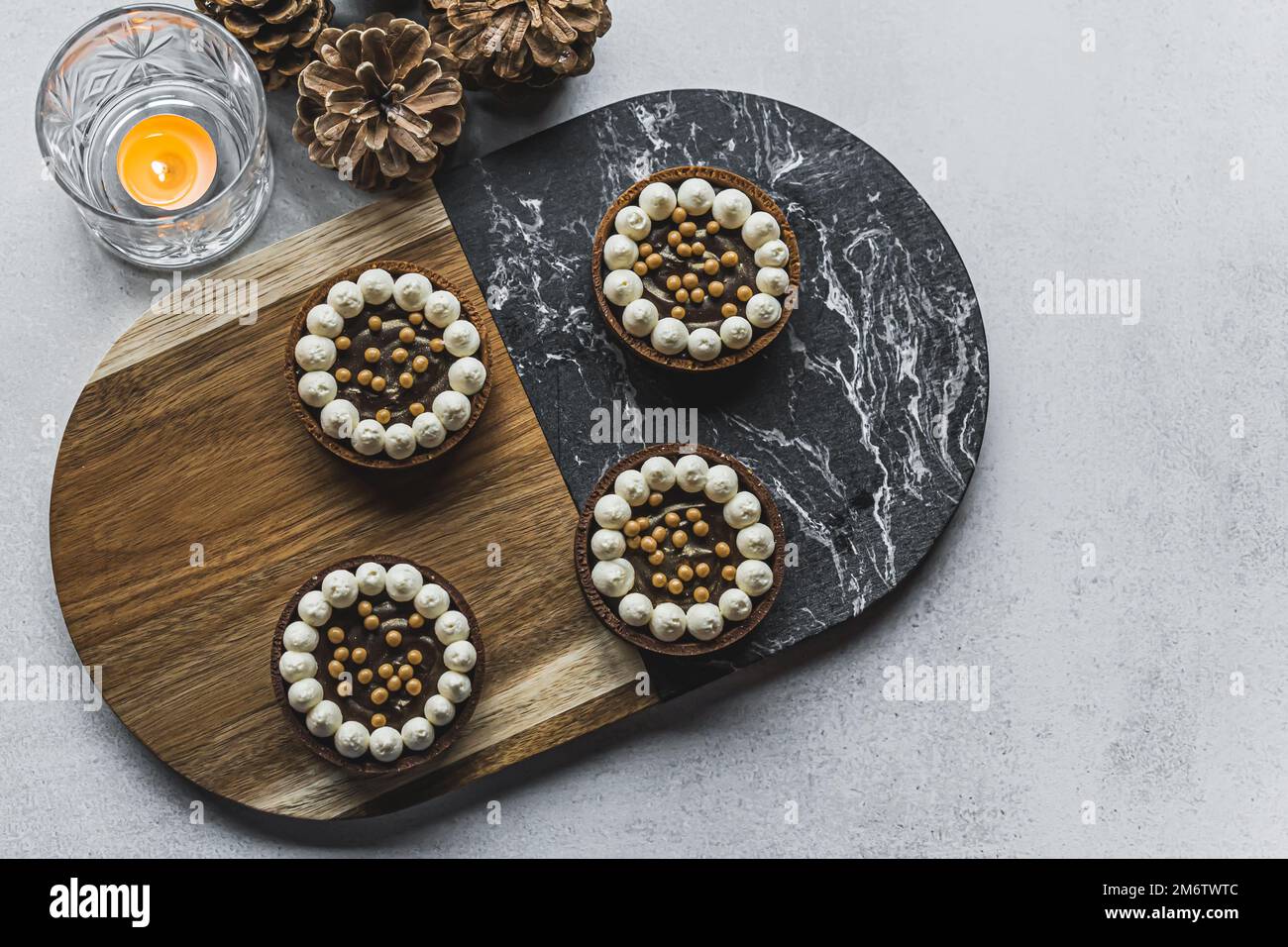 Top view of four beautiful small chocolate tarts decorated with small ...