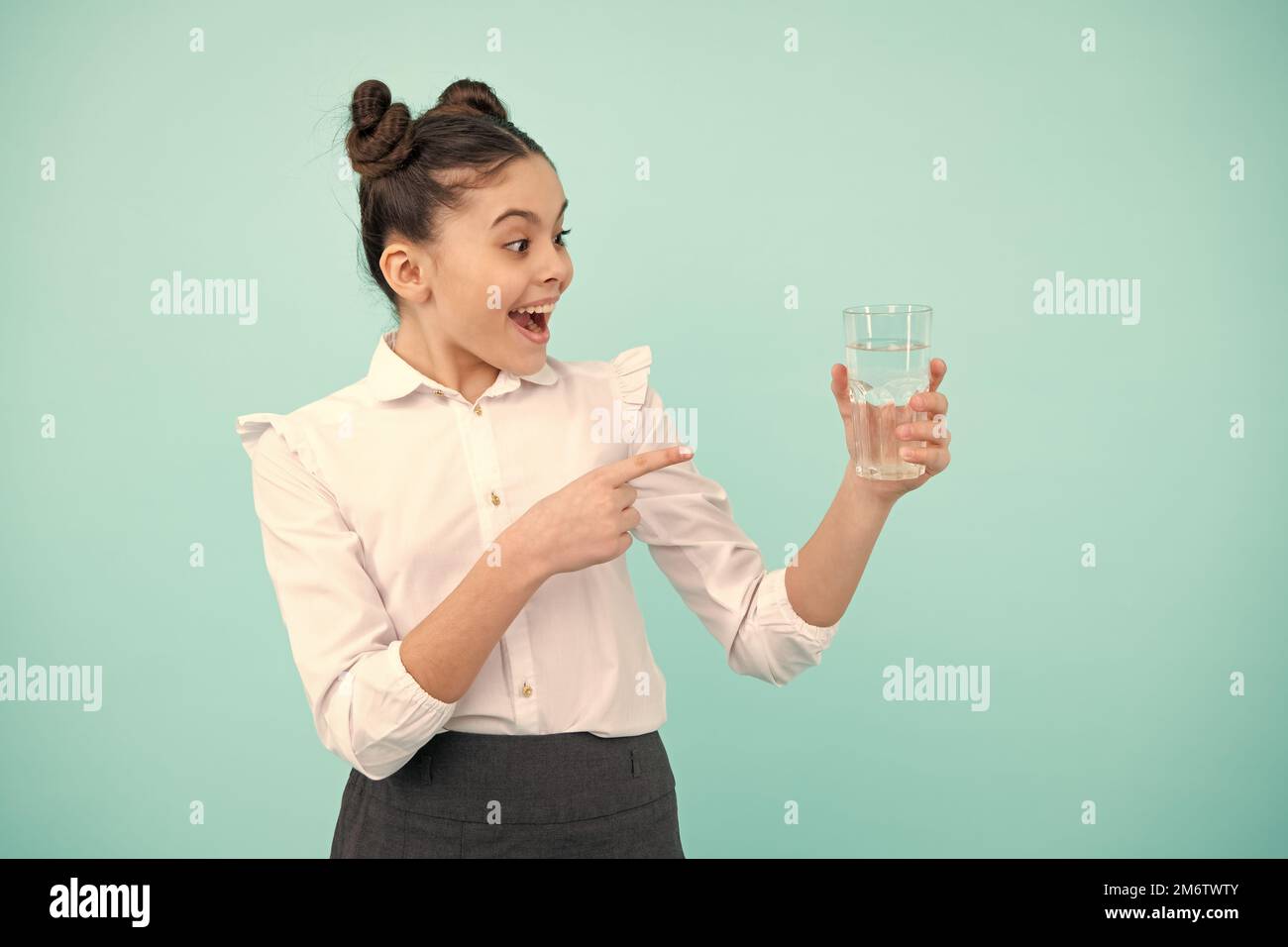 Teenager girl drinking water from glass on blue background. Daily life ...